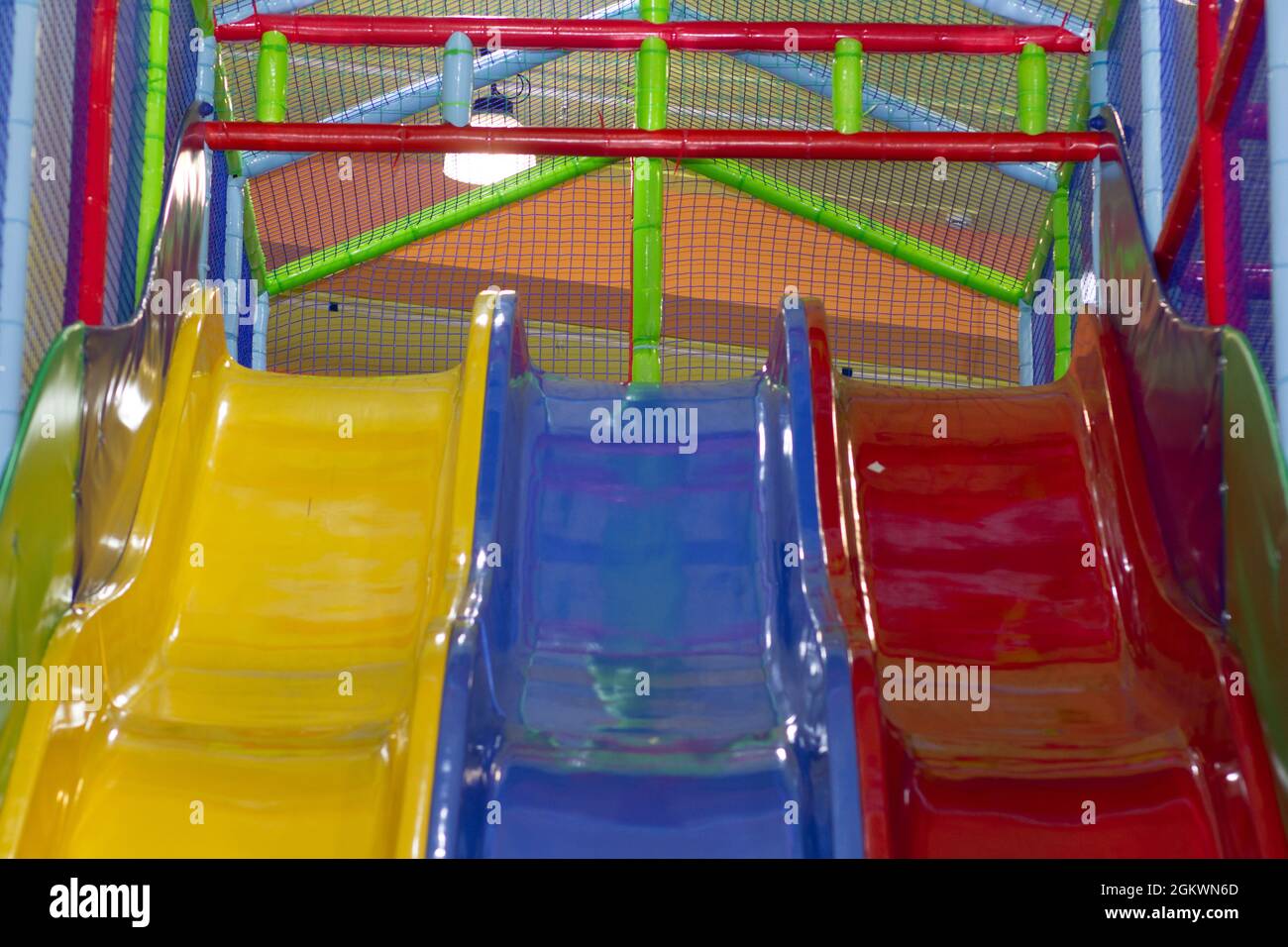 Three colorful slides for children in play center inside Stock Photo ...