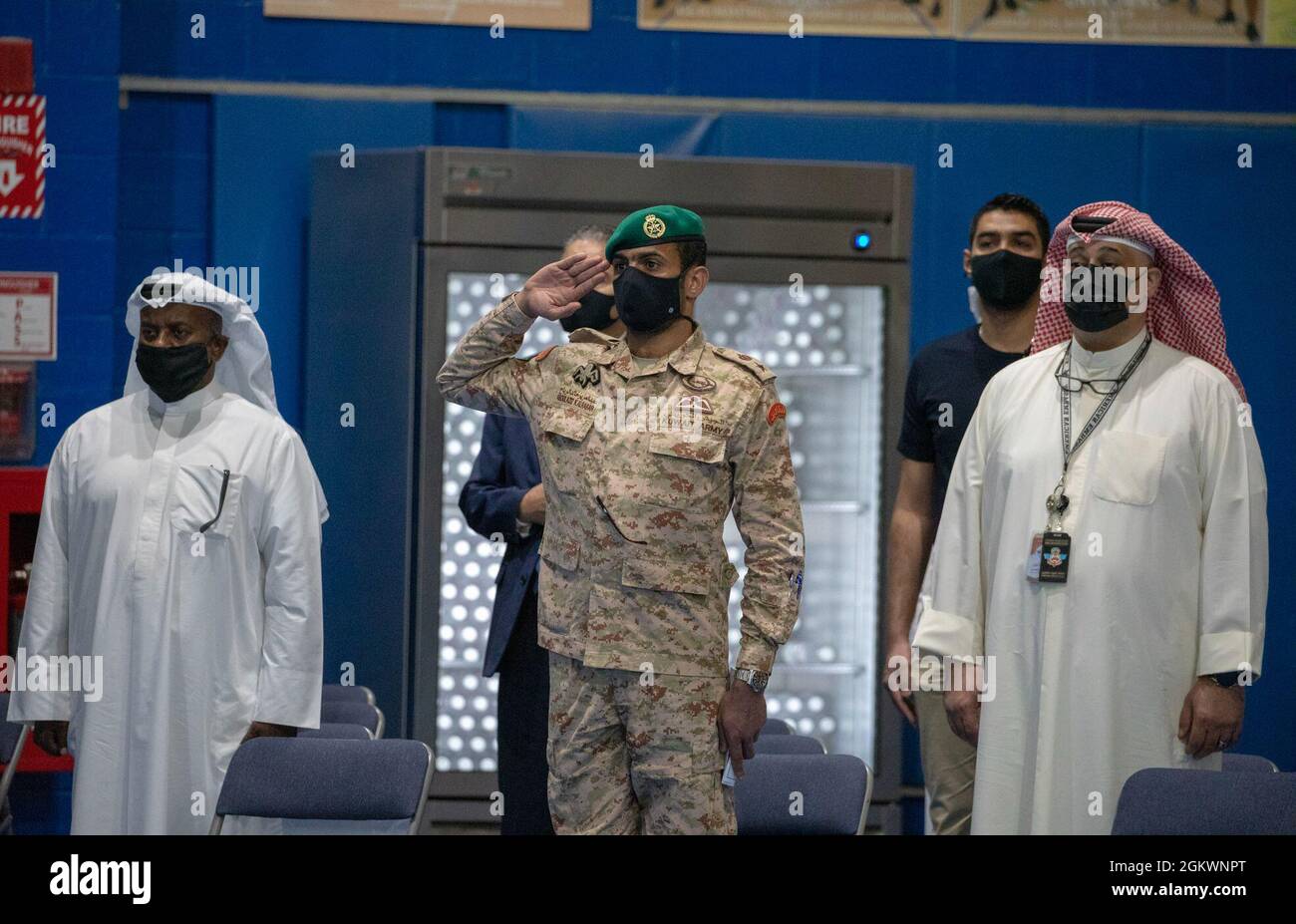 Kuwaiti distinguished guests stand and salute during the playing of the ...