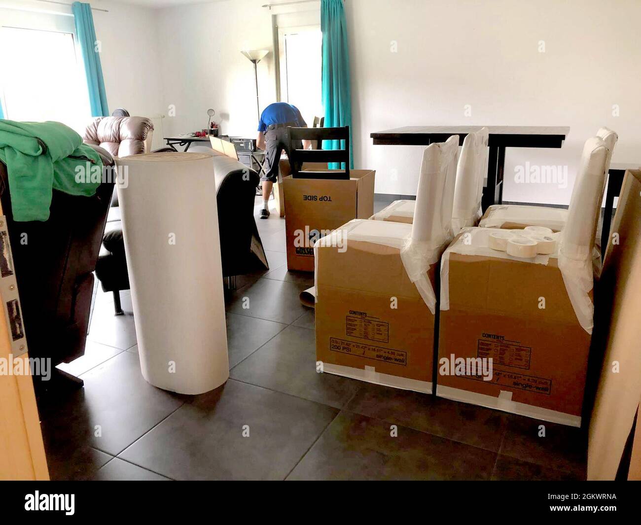 An employee of a German moving company packs up a dining set of an ...