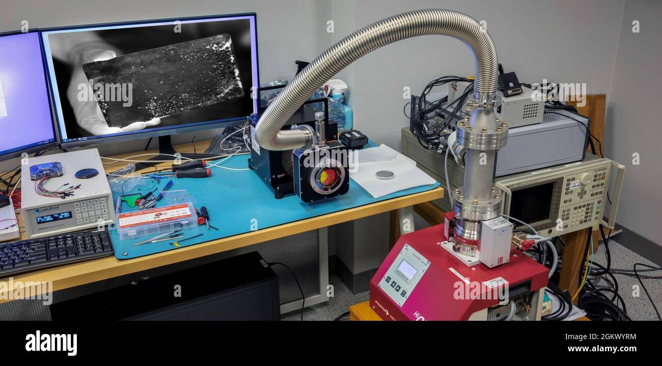 A sensor examines a metal plate for rust. The red machine acts as a ...