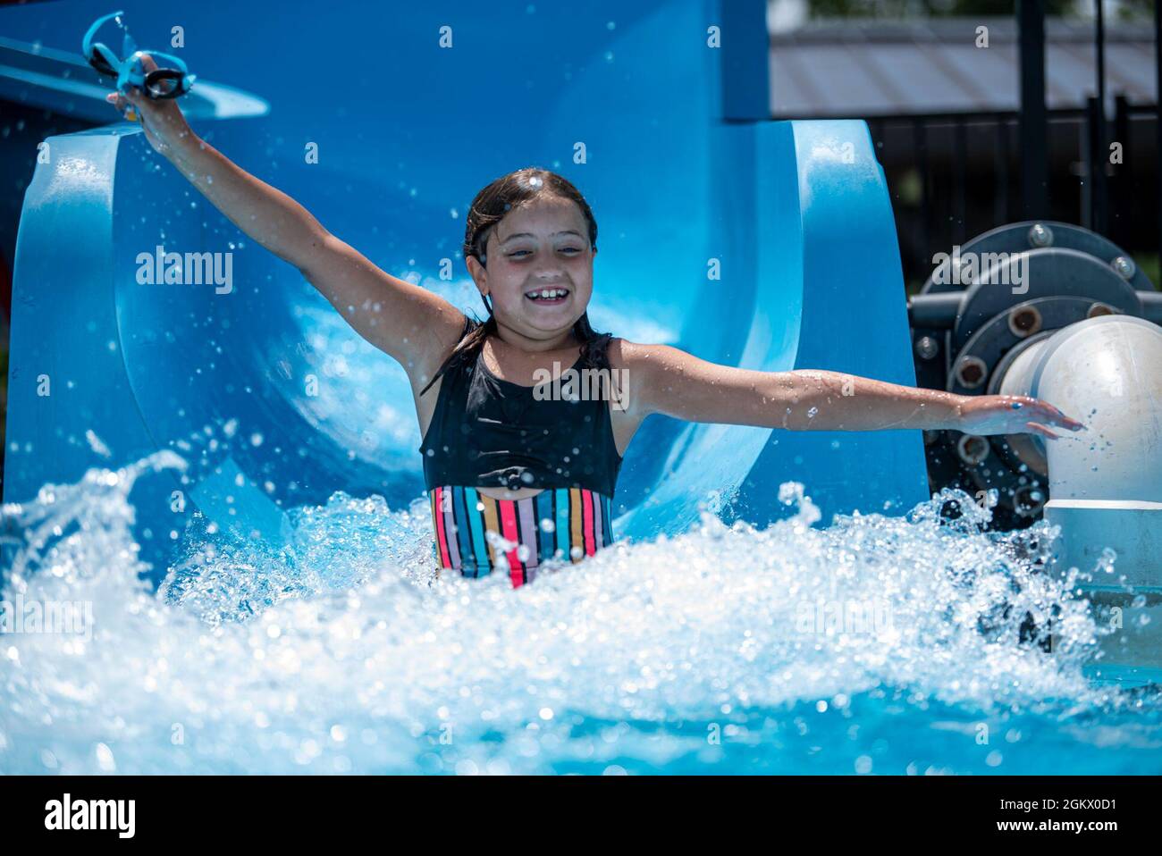 A member of Team Dover slides down the waterslide at the Oasis Pool on ...