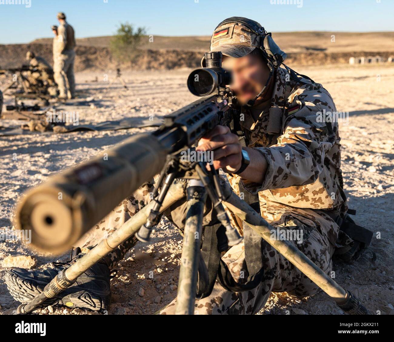 A German Army Sniper adjusts his scope during morning shooting ...