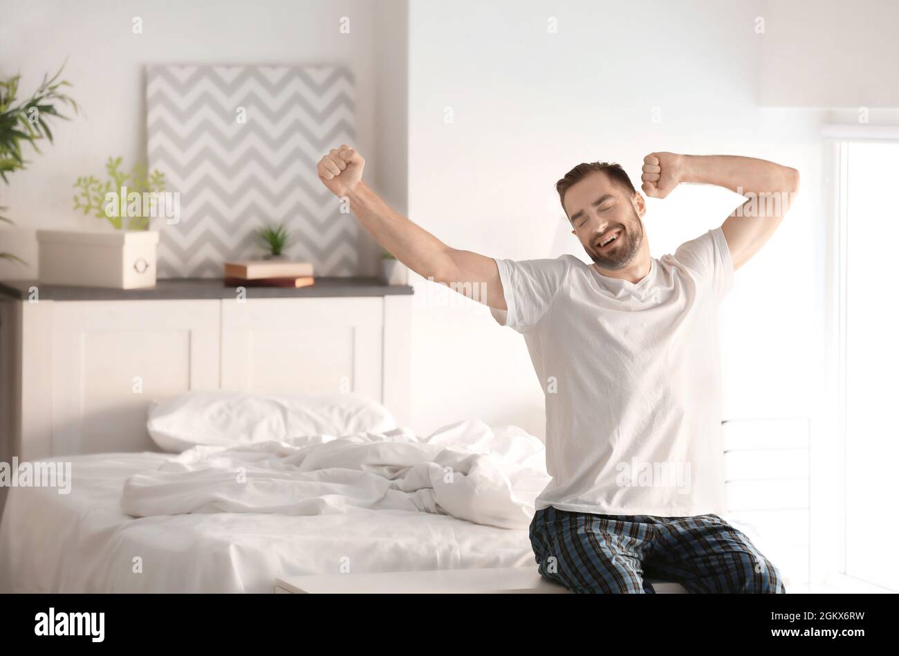 Morning of handsome young man sitting on bed at home Stock Photo - Alamy