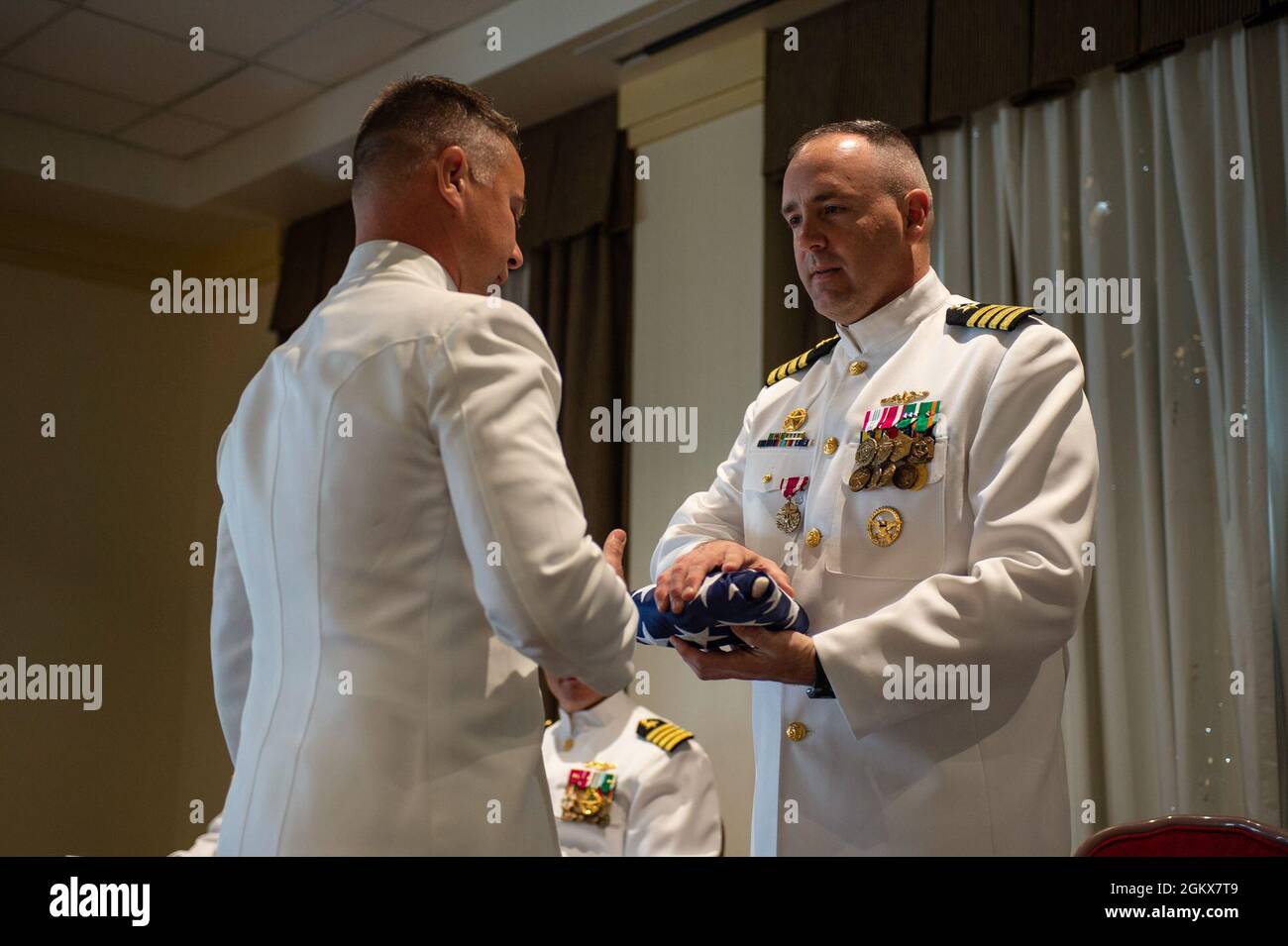 Capt. Michael Delaney, right, receives the first ensign ever flown on ...