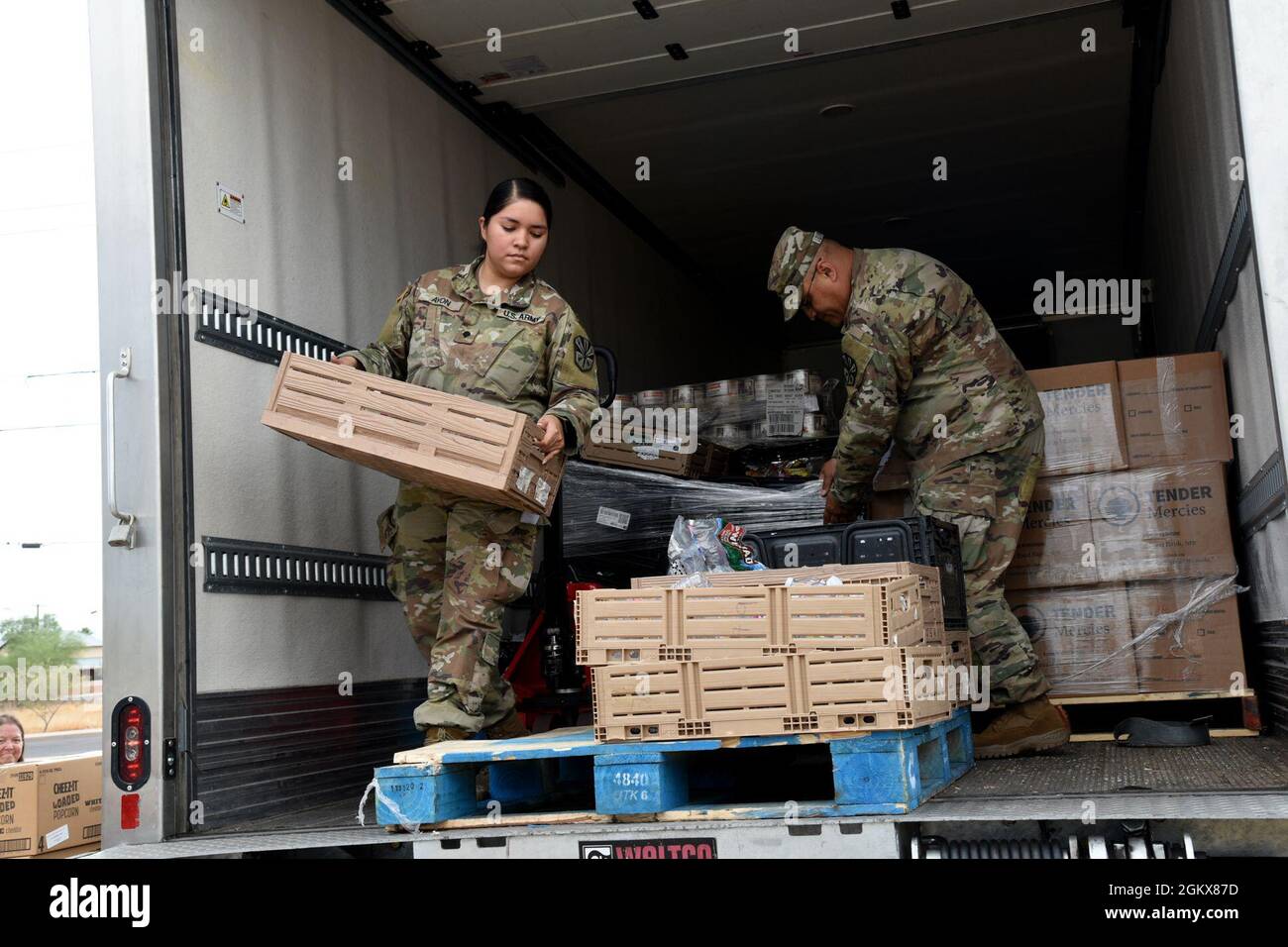 Arizona Army National Guard Soldiers load boxes of groceries into a ...