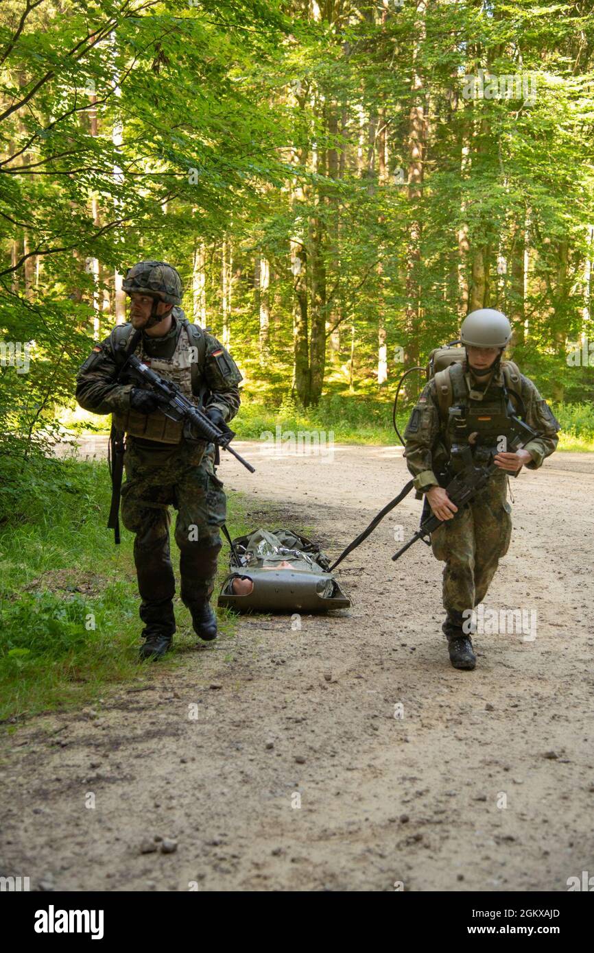 German soldiers use a skid to transport a simulated casualty during ...