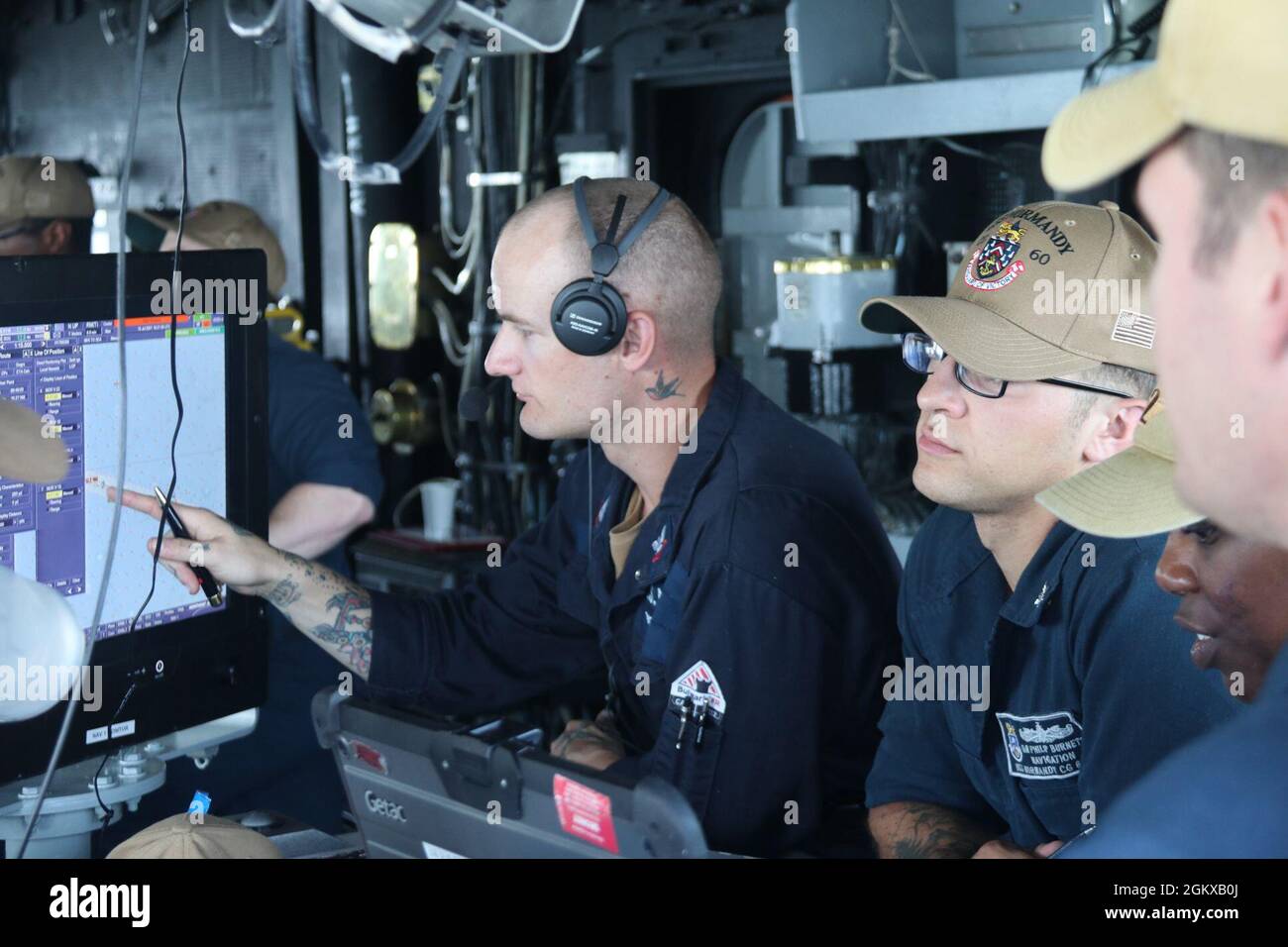 Quartermaster 2nd Class Milo Mai, left, verifies the ship’s track ...