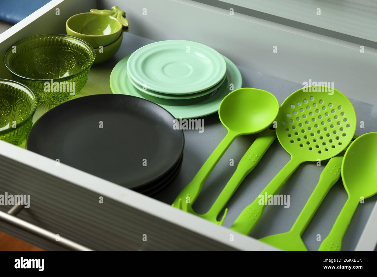 Set of dishware and kitchen utensils in drawer Stock Photo - Alamy
