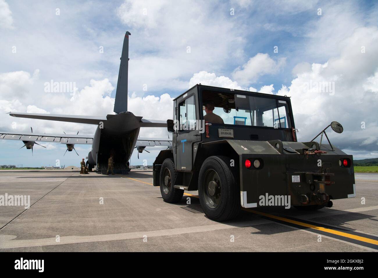 An MB-4 tow vehicle sits in front of a C-130J Super Hercules before ...