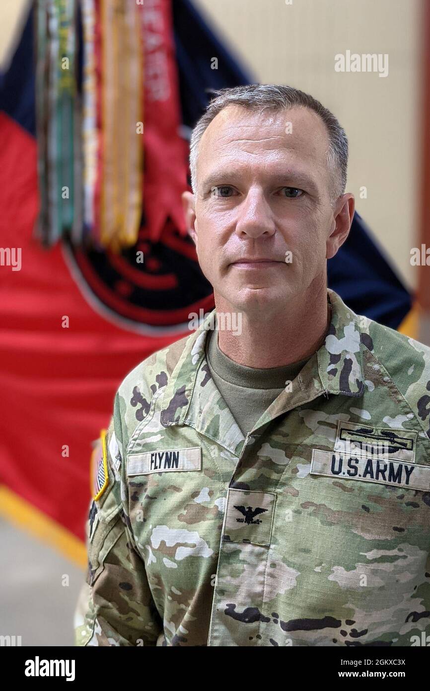 New York Army National Guard Col. Sean Flynn poses in front of the colors of the 27th Infantry ...