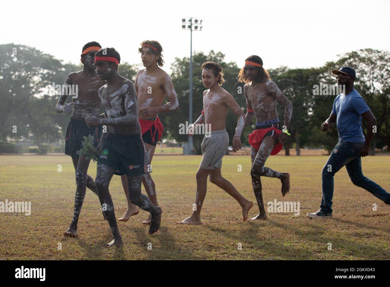 Members of the Dagoman Tribe perform a traditional dance with an Airman ...