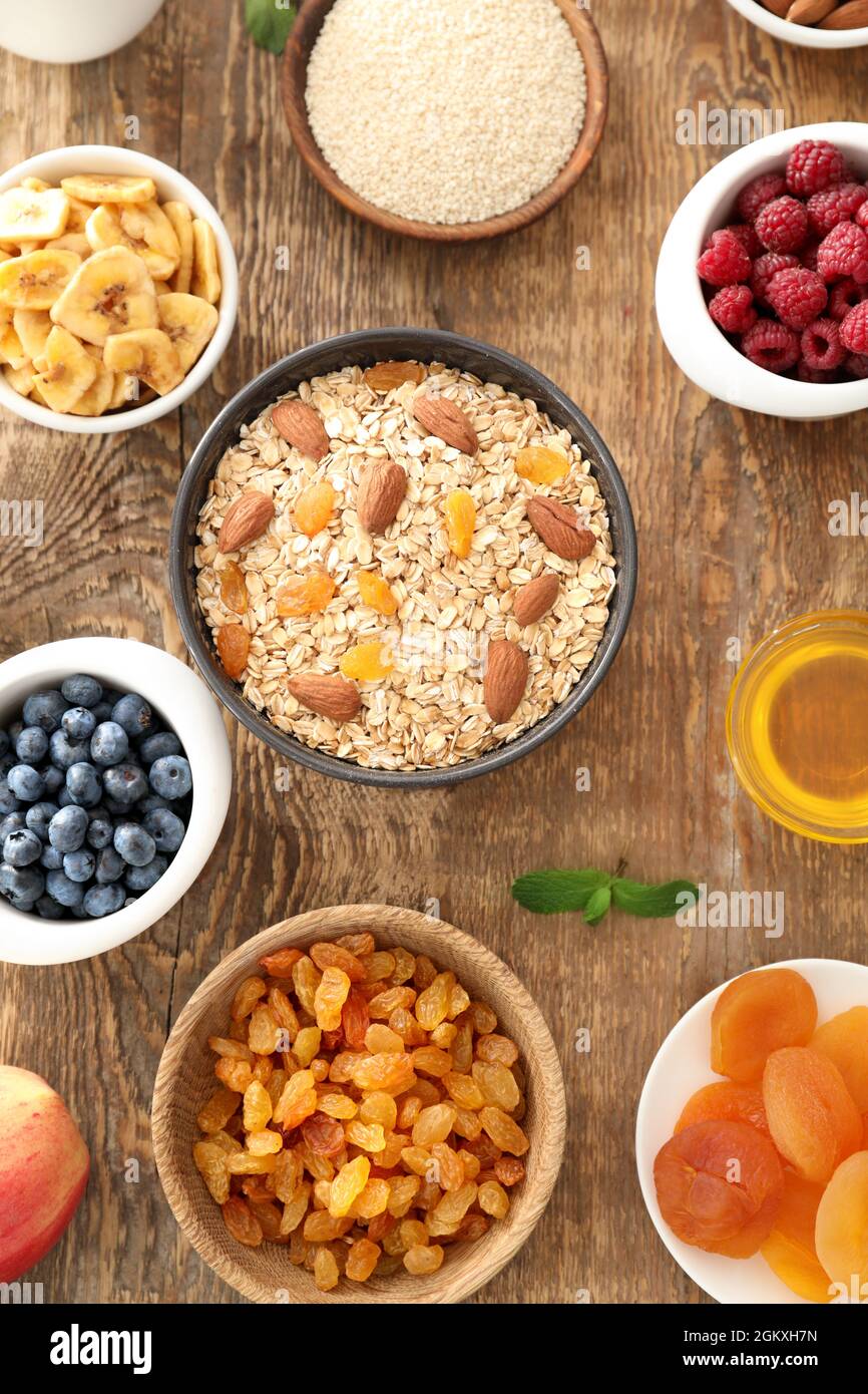 Oatmeal flakes and many different toppings on wooden background Stock ...