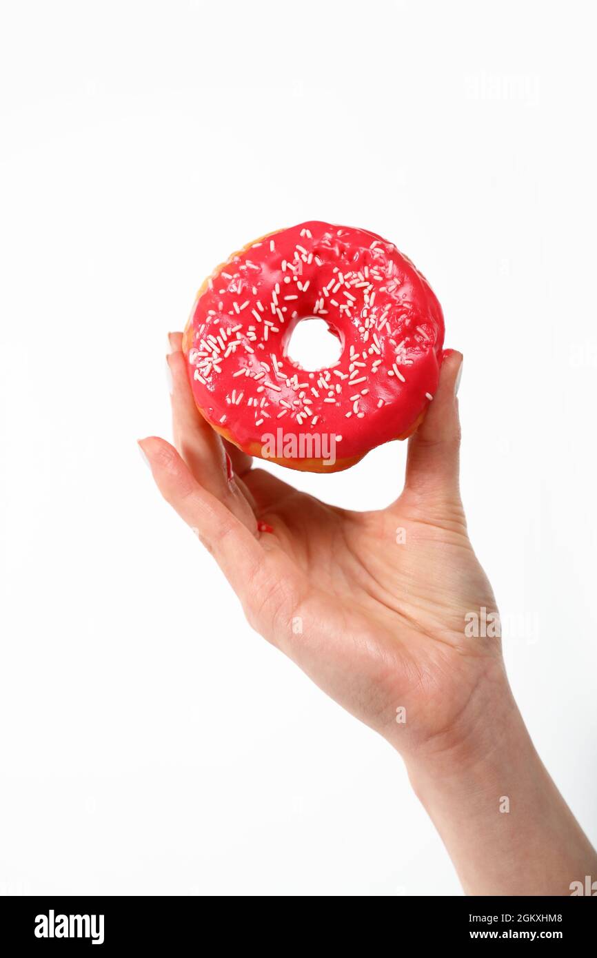 Close up Caucasian woman hand holding one red icing glazed ring ...