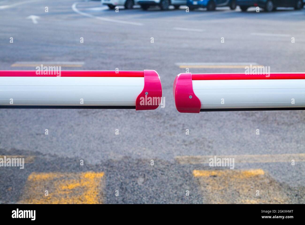 Closed barrier on carpark. Two white and red staves and asphalt with ...