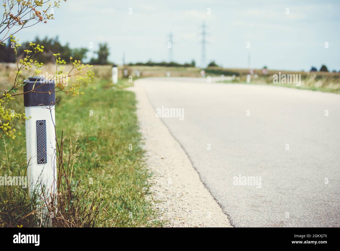 Road marker post near an empty road Stock Photo - Alamy