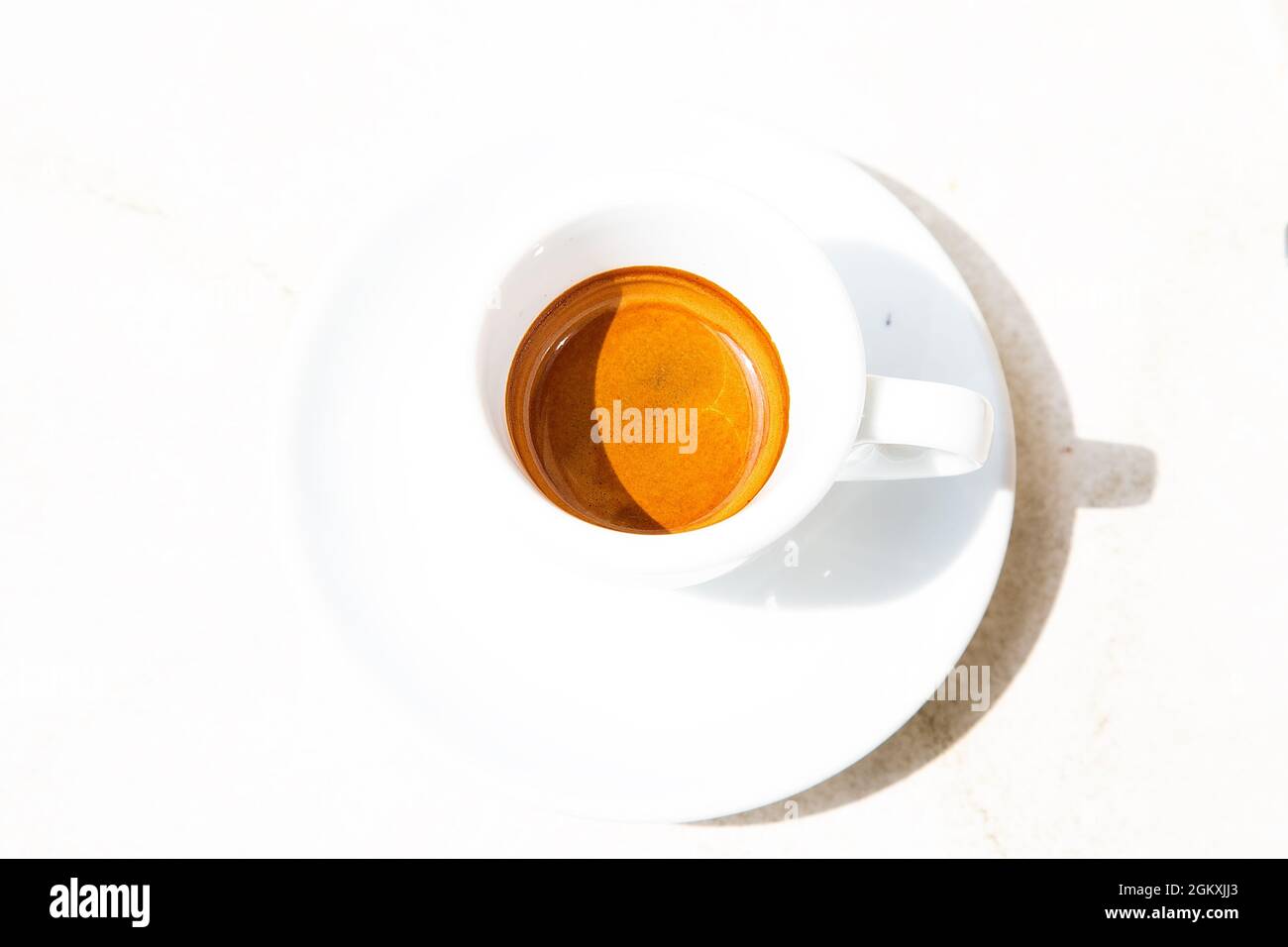 Round white coffee cup on white surface. High contrast picture ...
