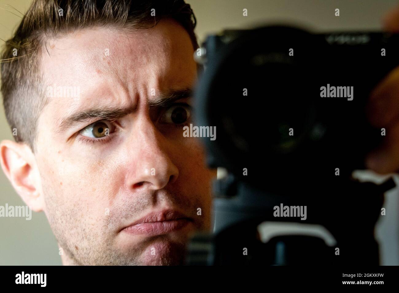 Cameraman from Argentina working on his camera with a confused facial ...