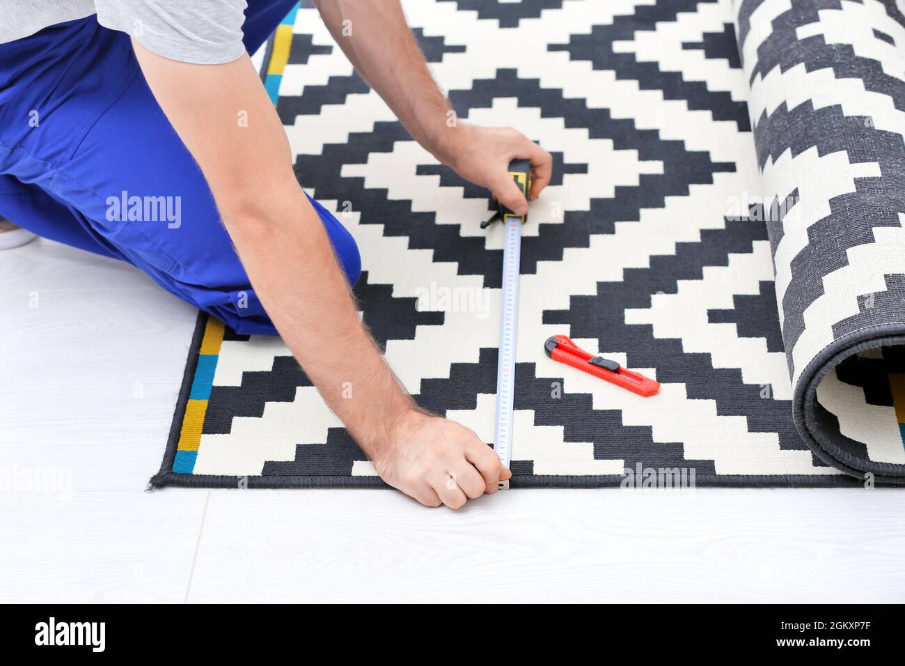 Male worker fitting carpet on floor indoors Stock Photo - Alamy