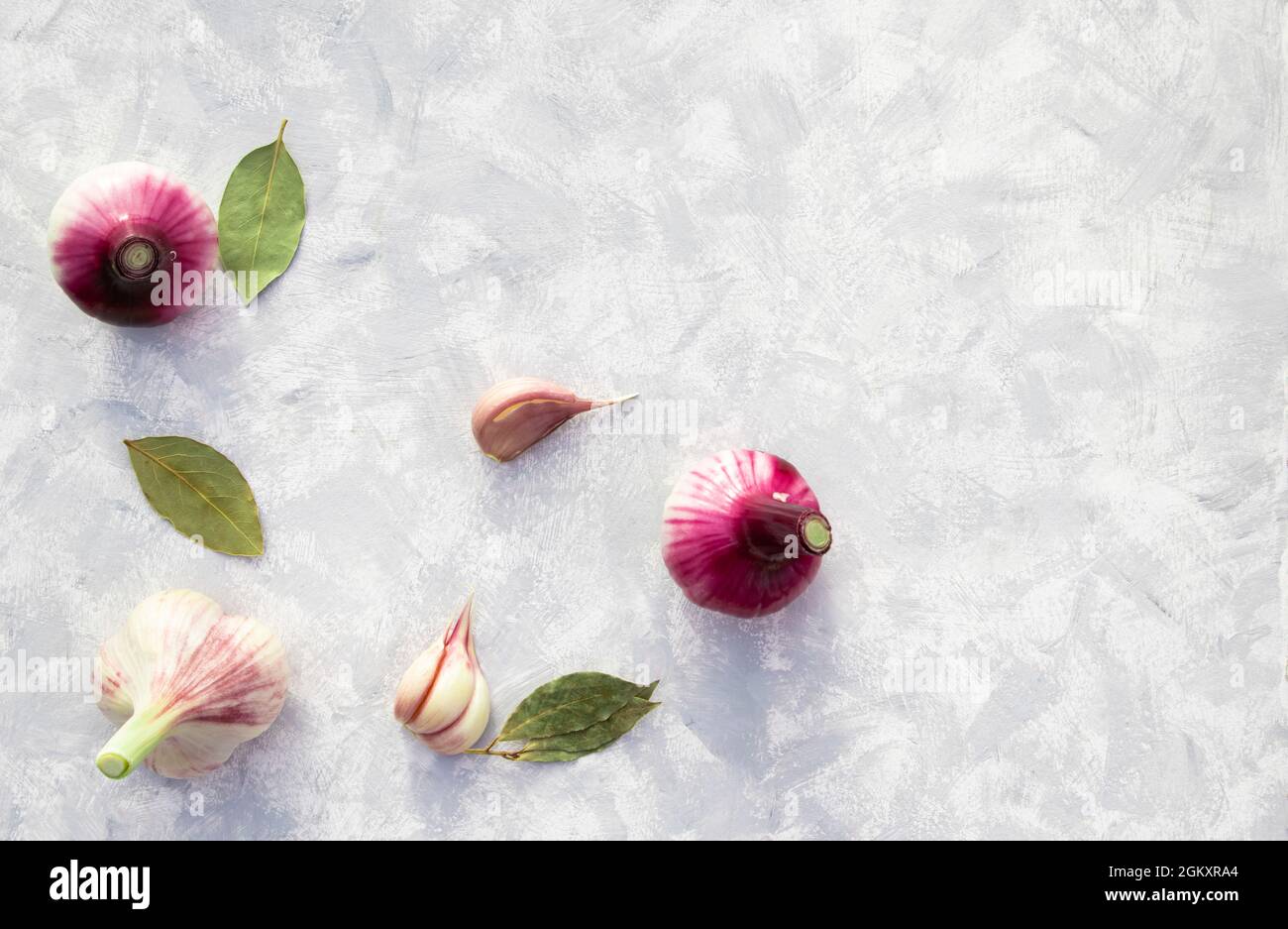 Composition of onions, garlic, bay leaves on a white background ...