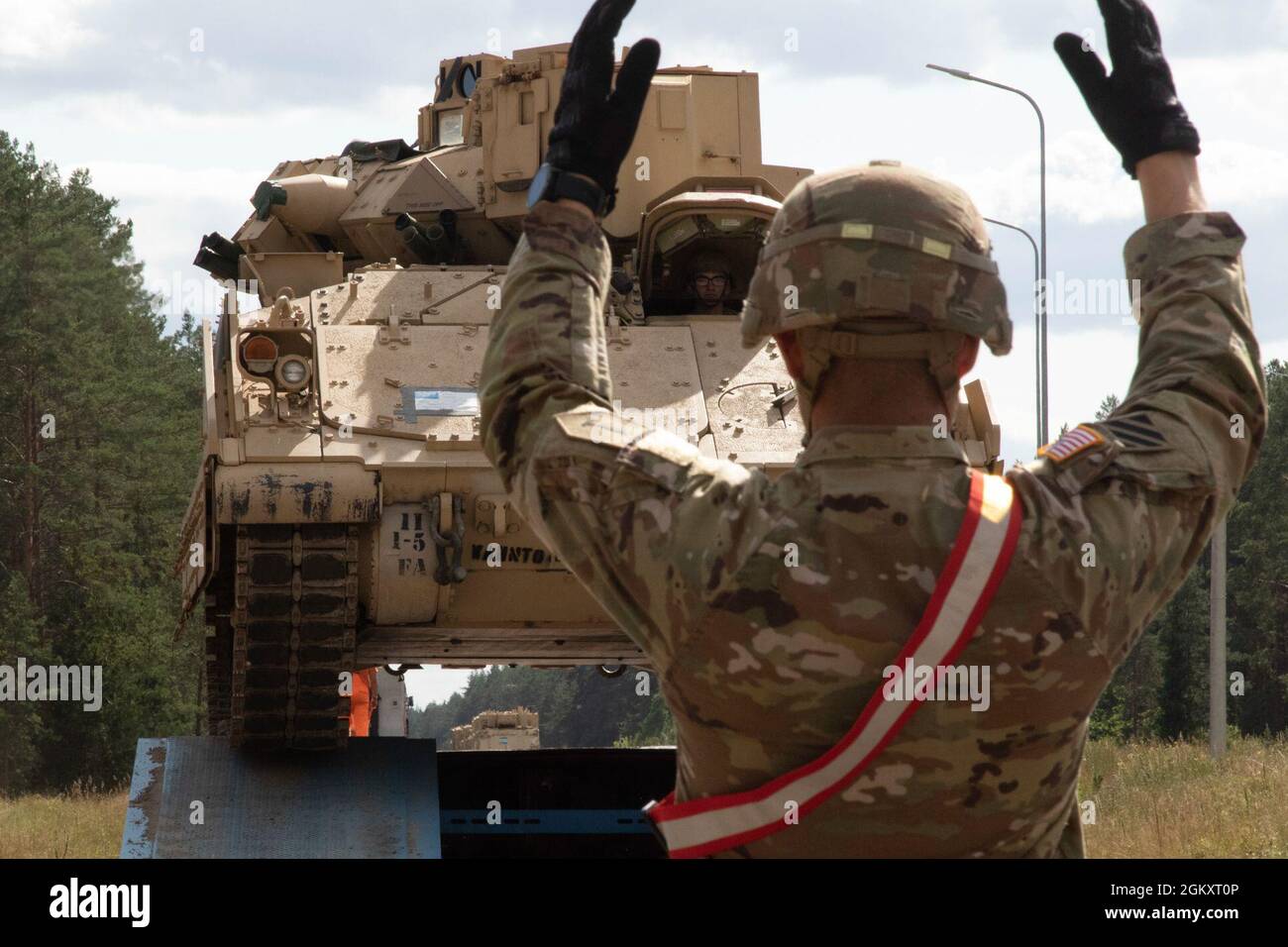 A Soldier, with the 3rd Battalion, 66th Armored Regiment, signals the ...