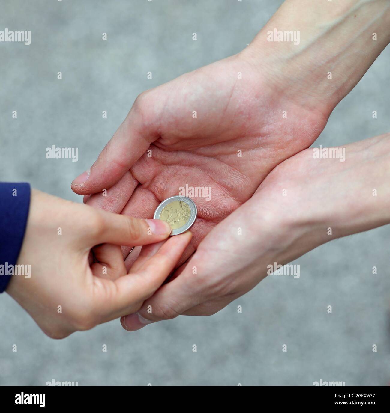 hand of the girl who gives a european coin to the poor beggar Stock ...