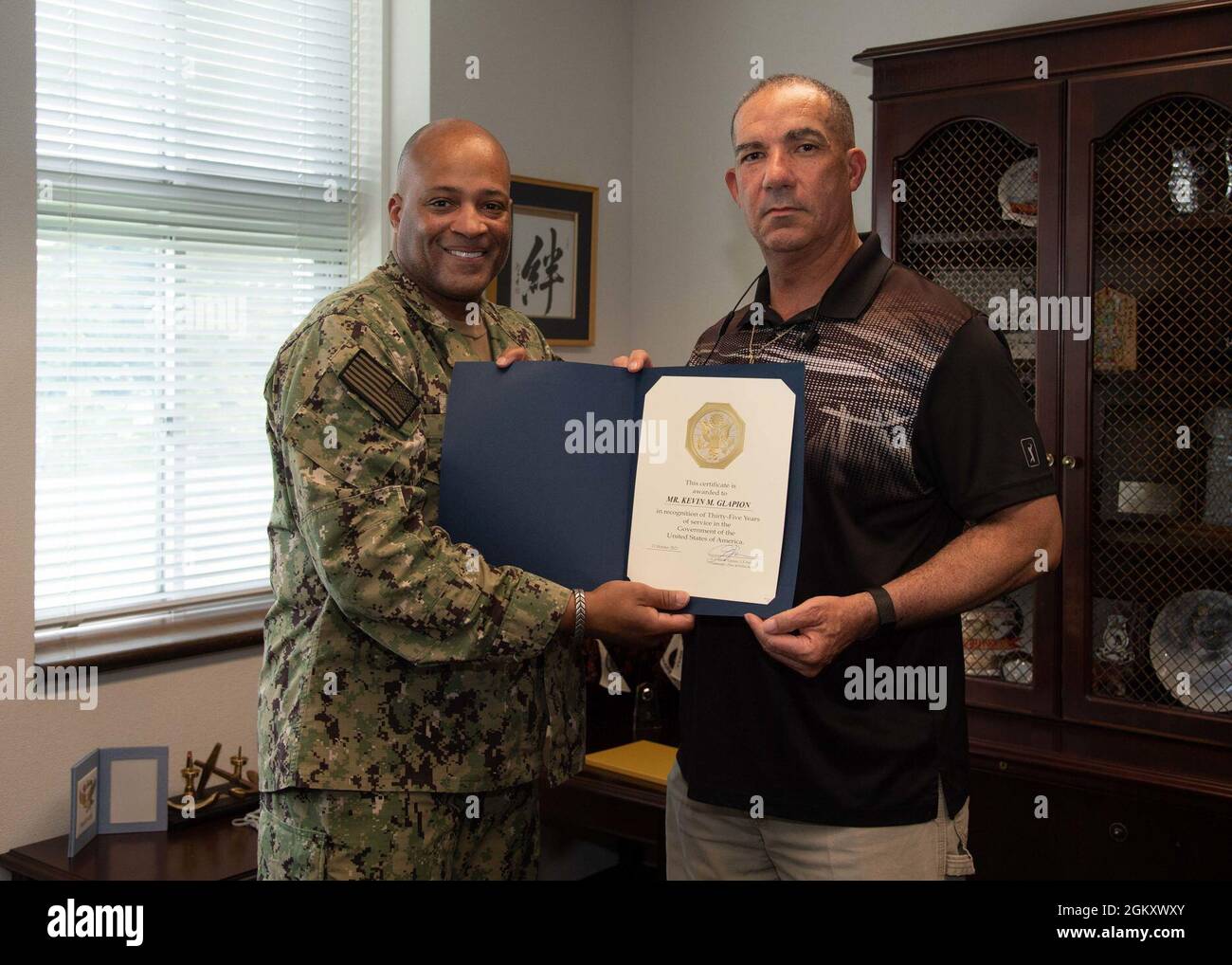 Commander, Fleet Activities Sasebo (CFAS) Capt. David Adams presents ...