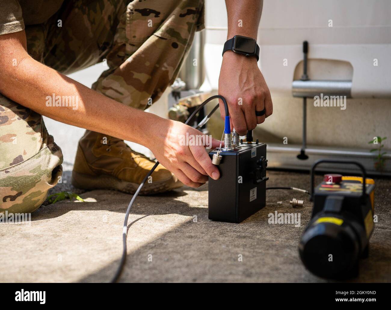 An explosive ordnance disposal technician plugs a cable into a Guardian ...