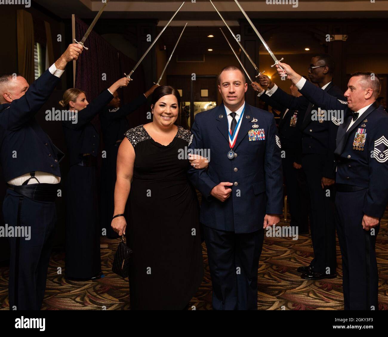 Promotees and their escort pose for a photo in front of the saber ...