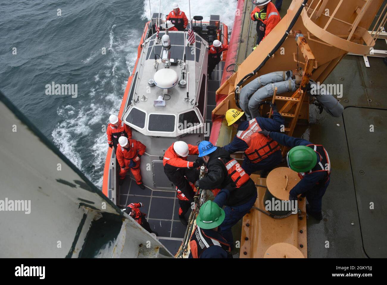 Coast Guard Cutter Healy crew members assist Coast Guard Cutter Midgett ...