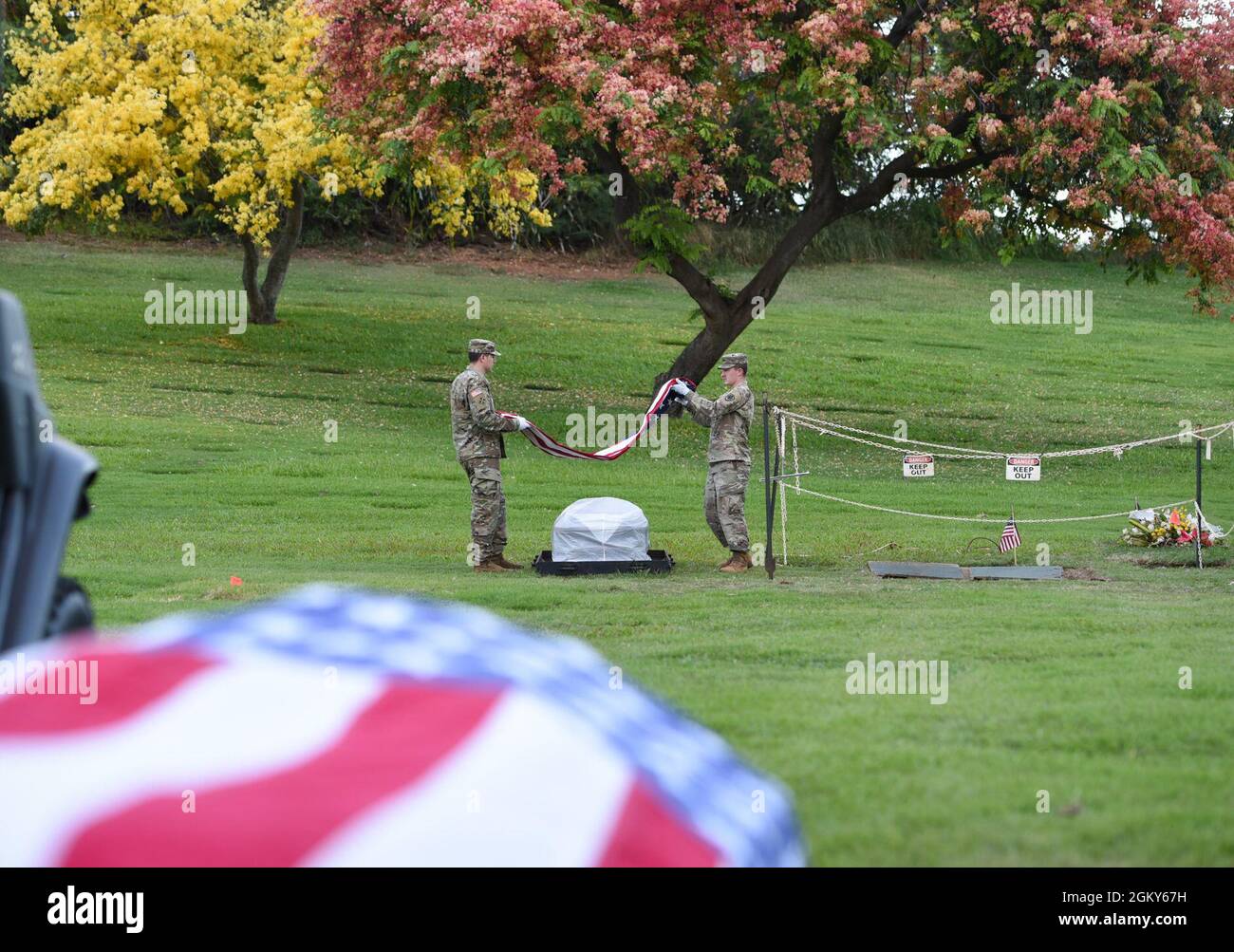 Members of the Defense POW/MIA Accounting Agency (DPAA) drape a flag on ...