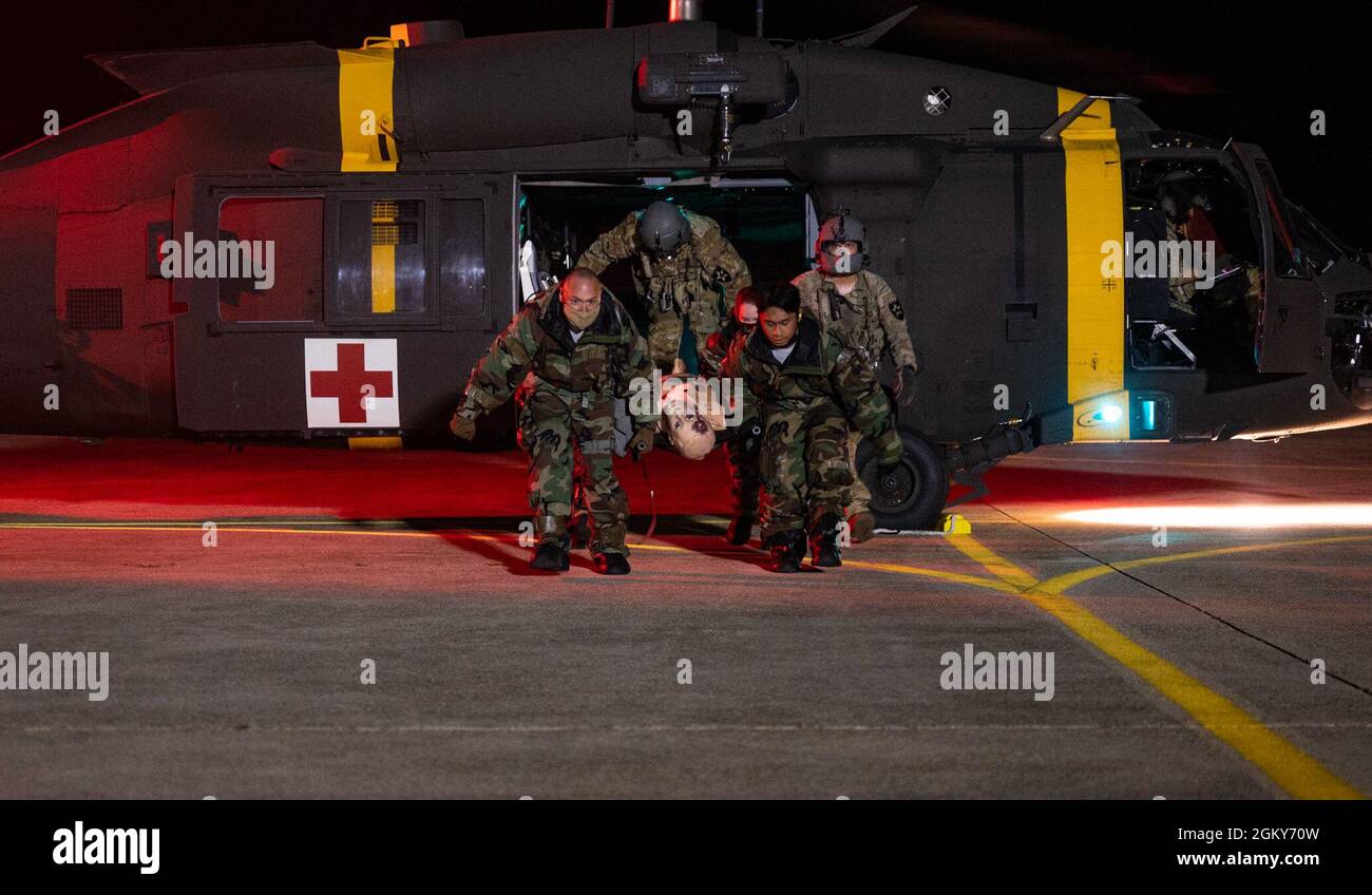 U.S. Airmen assigned to the 8th Medical Group transport a simulated ...