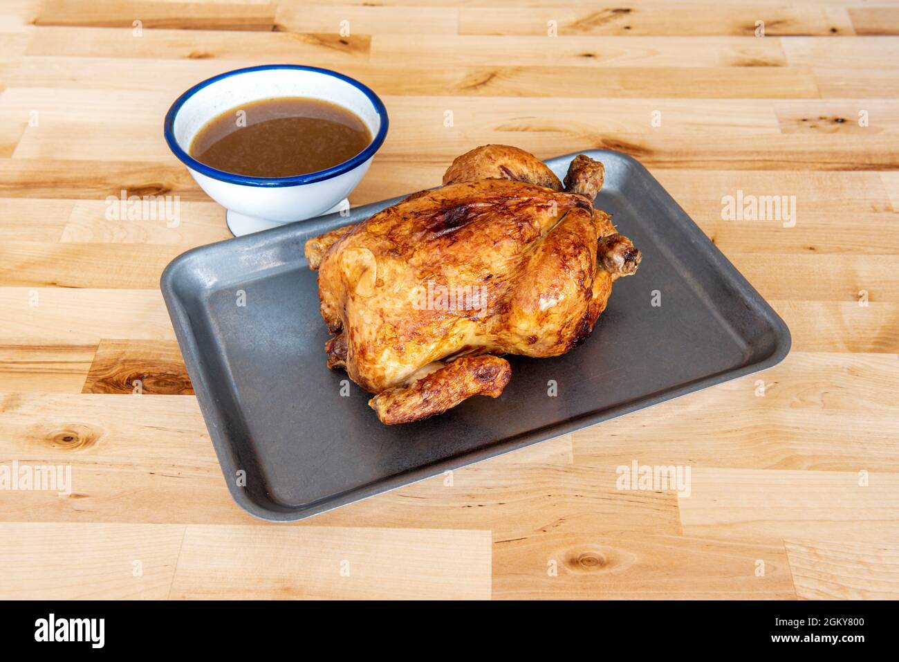 Typical roast chicken with its crispy skin on a metal tray accompanied ...