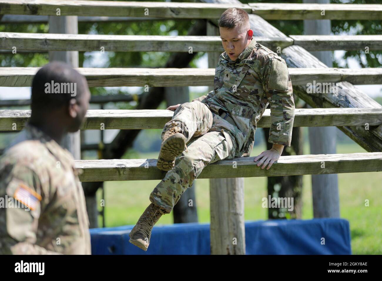 Spc. Alexander Haydon maneuvers across wooden beams during an obstacle ...