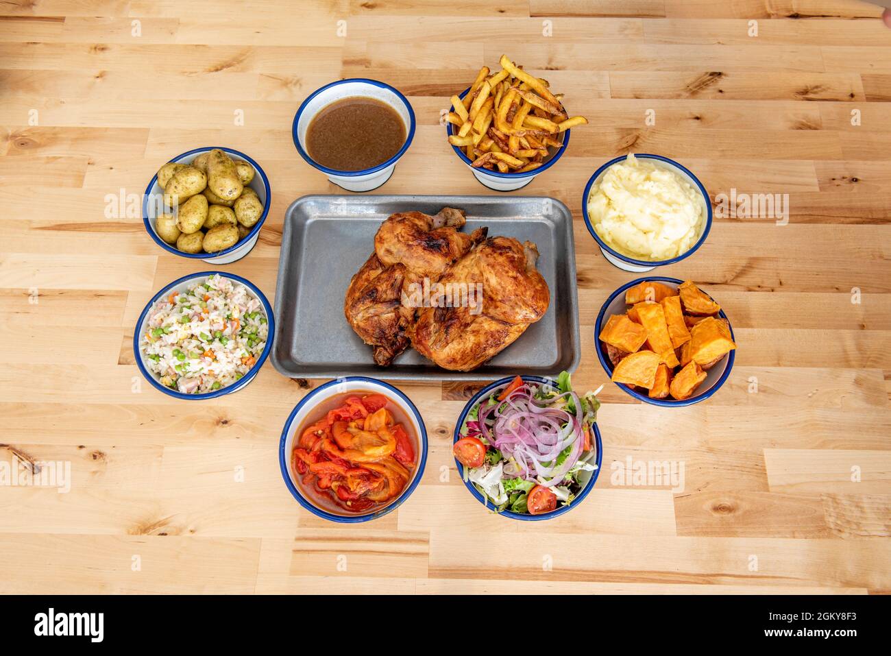 Roast chicken on a metal tray surrounded by all kinds of garnishes ...