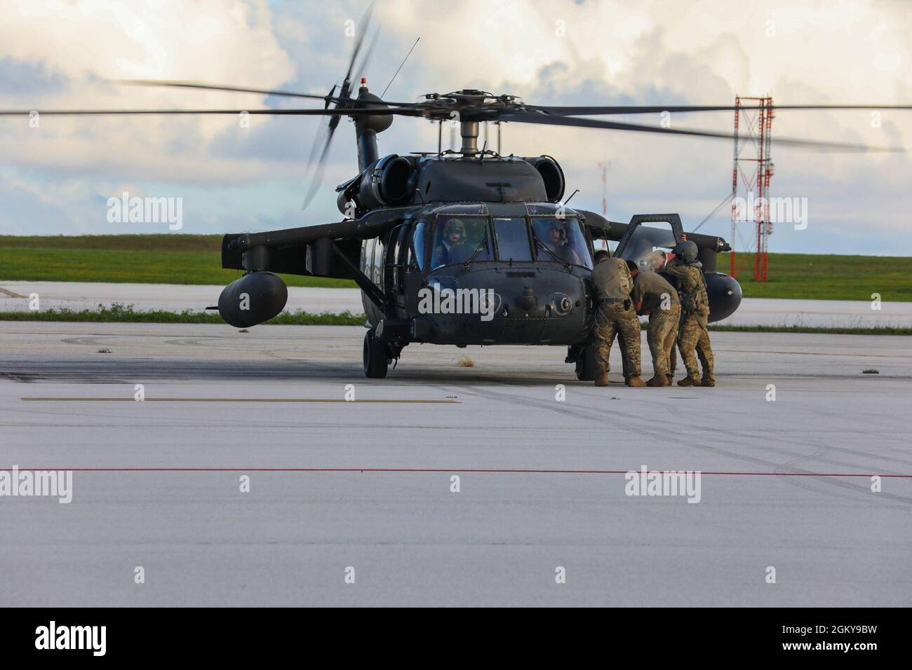 Crew members work on a UH-60 Black Hawk after arriving back to Andersen ...