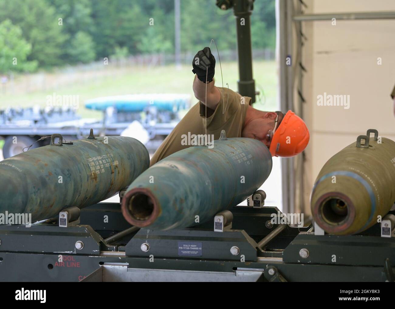 A U.S. Air Force systems munitions technician pulls a fuse wire through ...
