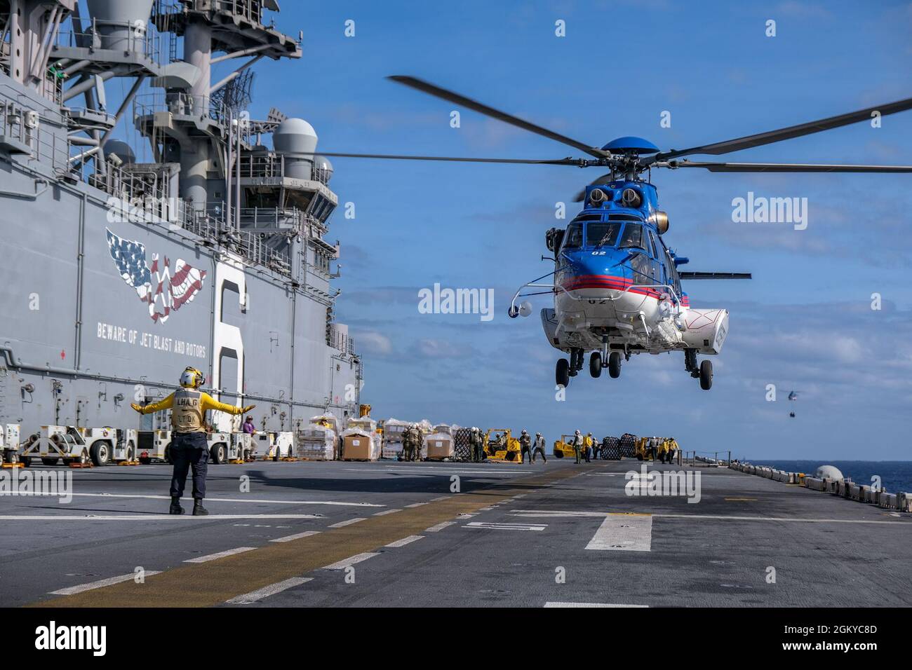 A U.S. Navy aviation boatswain’s mate guides an Erickson EC-225LP for ...