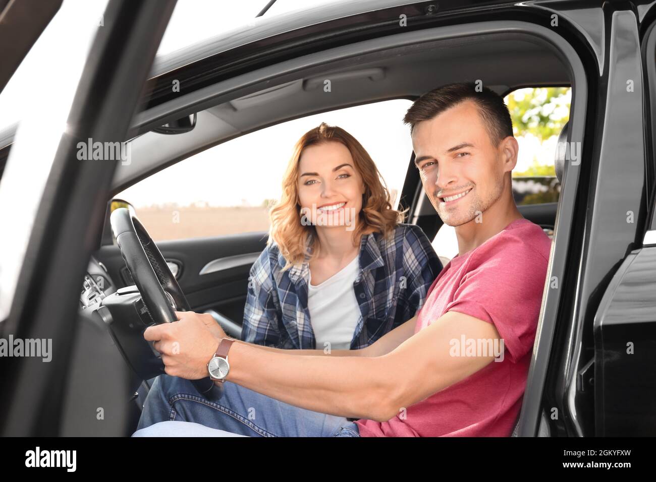 Beautiful young couple in car Stock Photo - Alamy