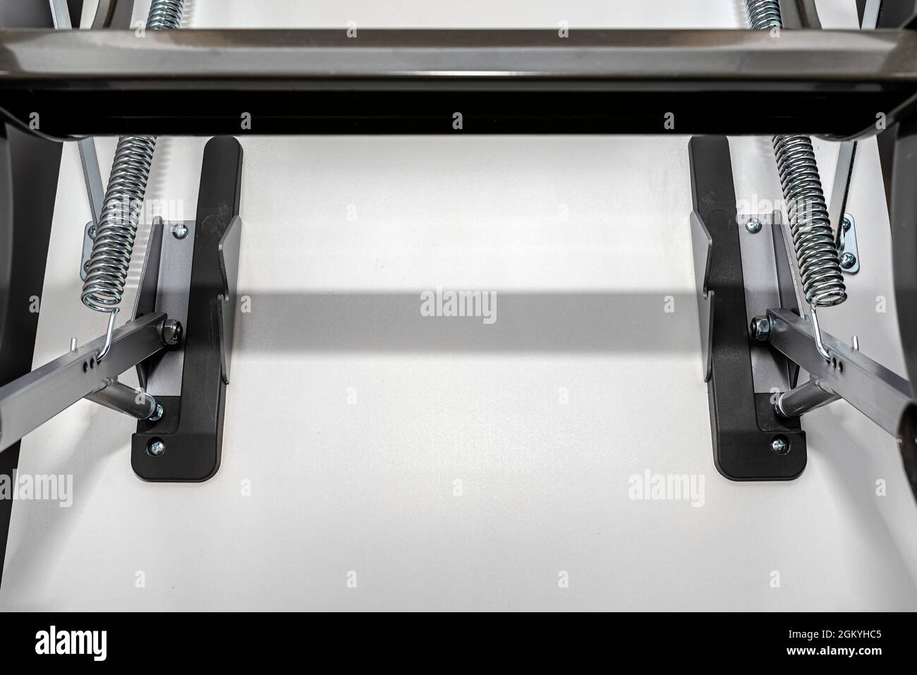 A spring tensioning mechanism that helps in opening a metal ladder to ...