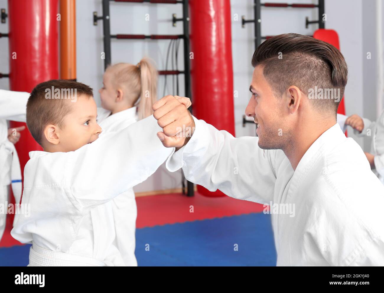 Male karate instructor training little children in dojo Stock Photo - Alamy