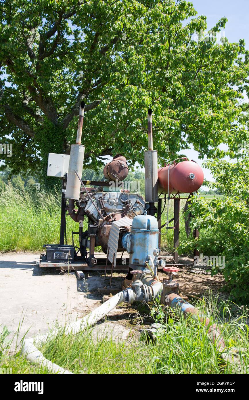 Vertical shot of old pumping equipment set with pipes outdoors under ...