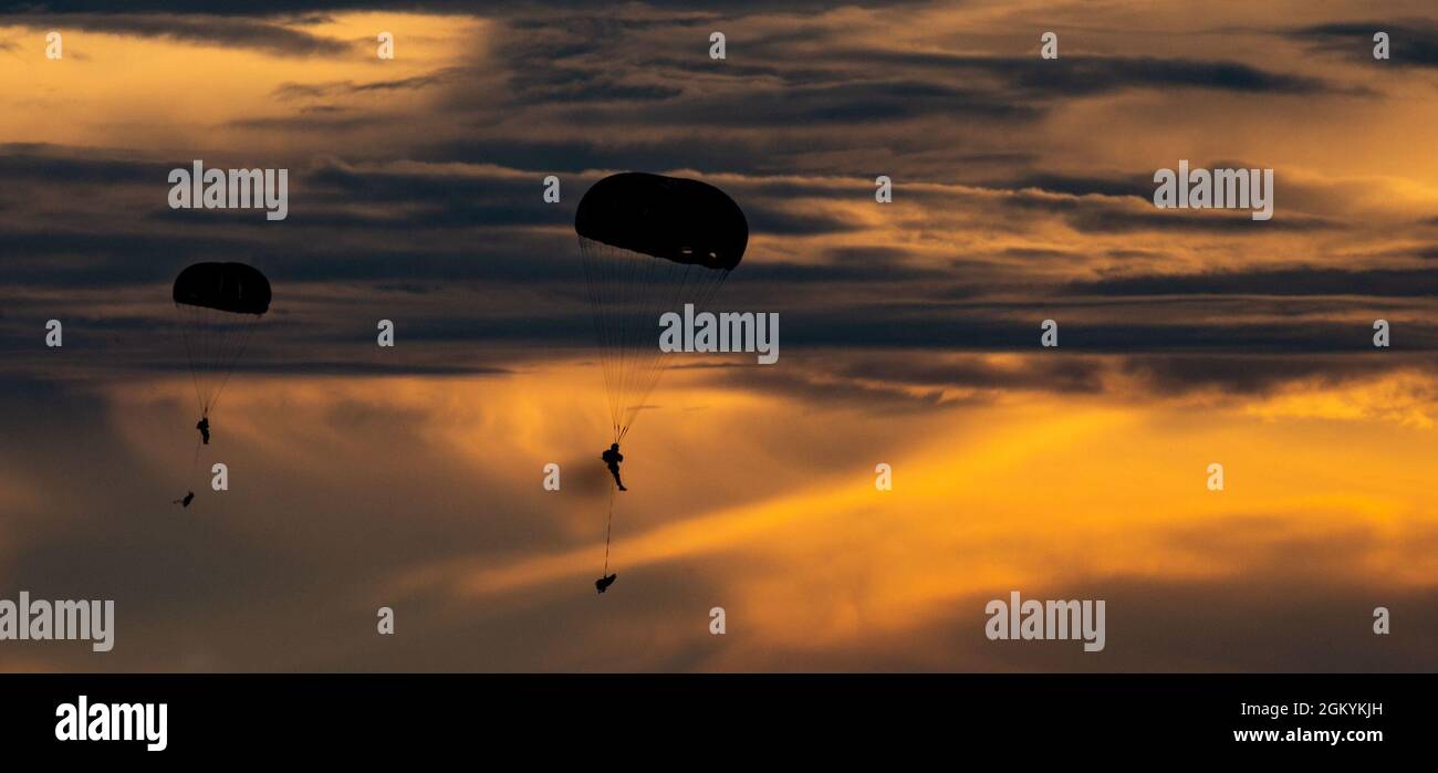 U.S. Army paratroopers descend from the sky during Exercise Forager 21 ...