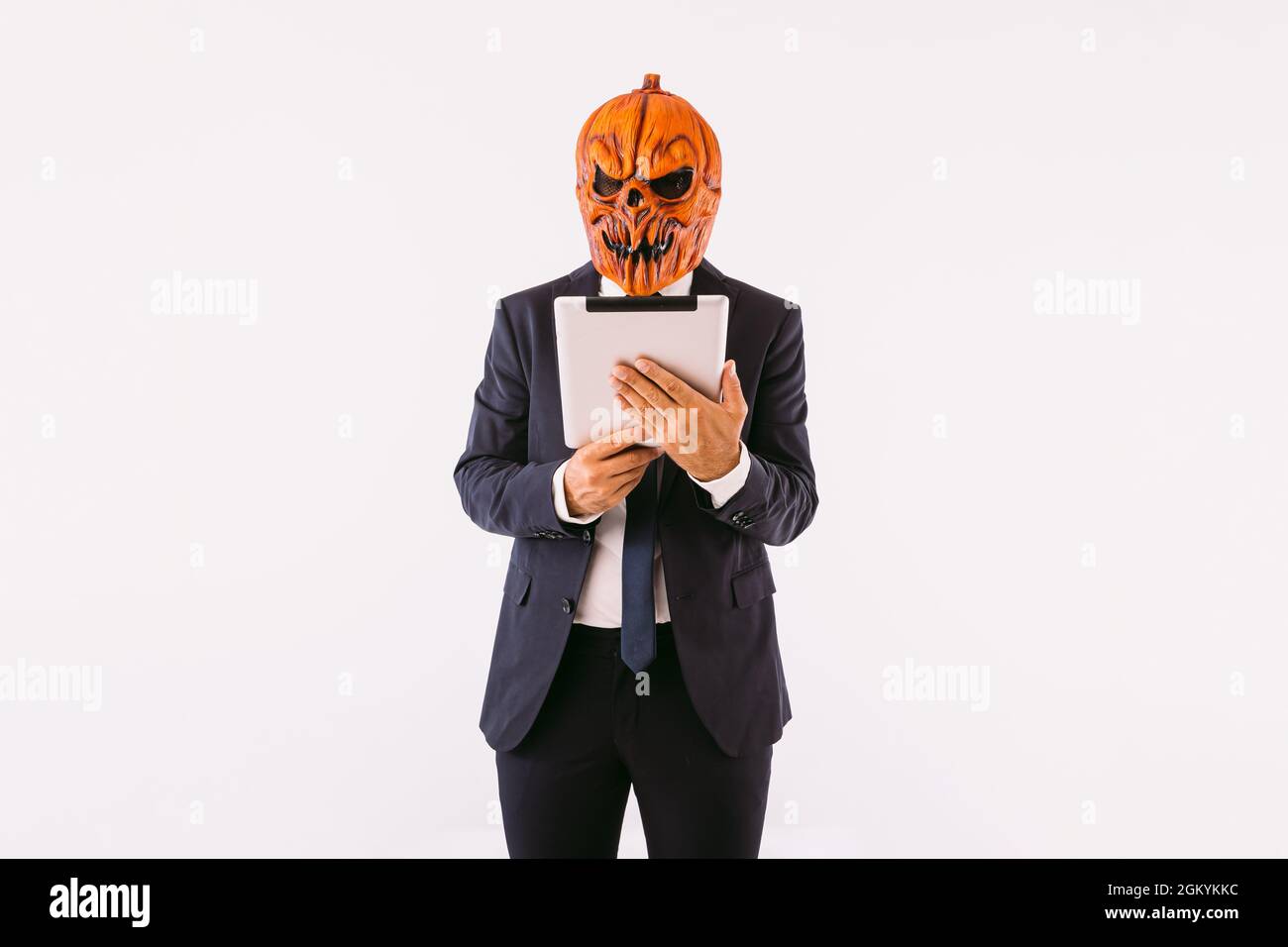 Man wearing jacket suit, blue tie and Jack-o-lantern pumpkin mask ...