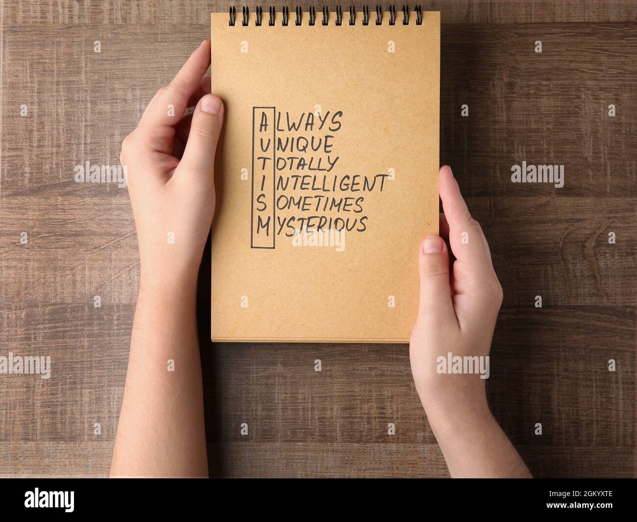 Woman holding notepad on wooden background. Autism concept Stock Photo ...