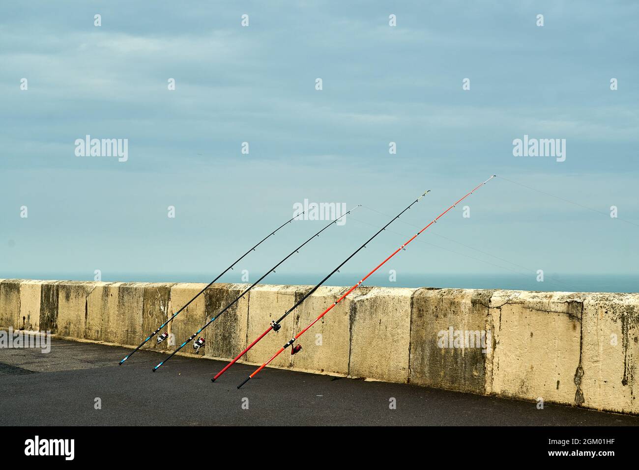 Fishing rods leaning on the stone structure Stock Photo - Alamy