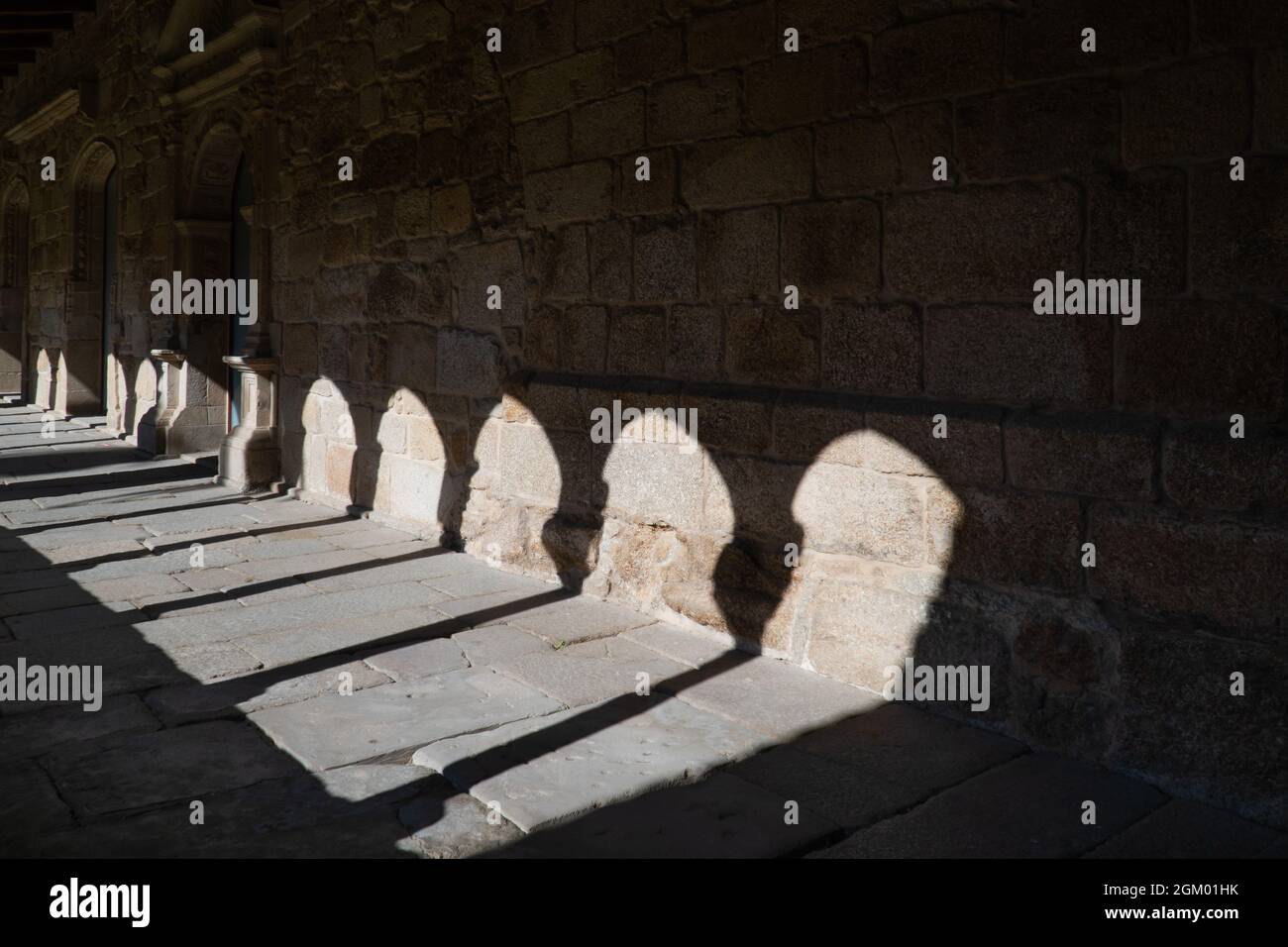 Shadows of columns falling on a brick wall in the courtyard of an ...