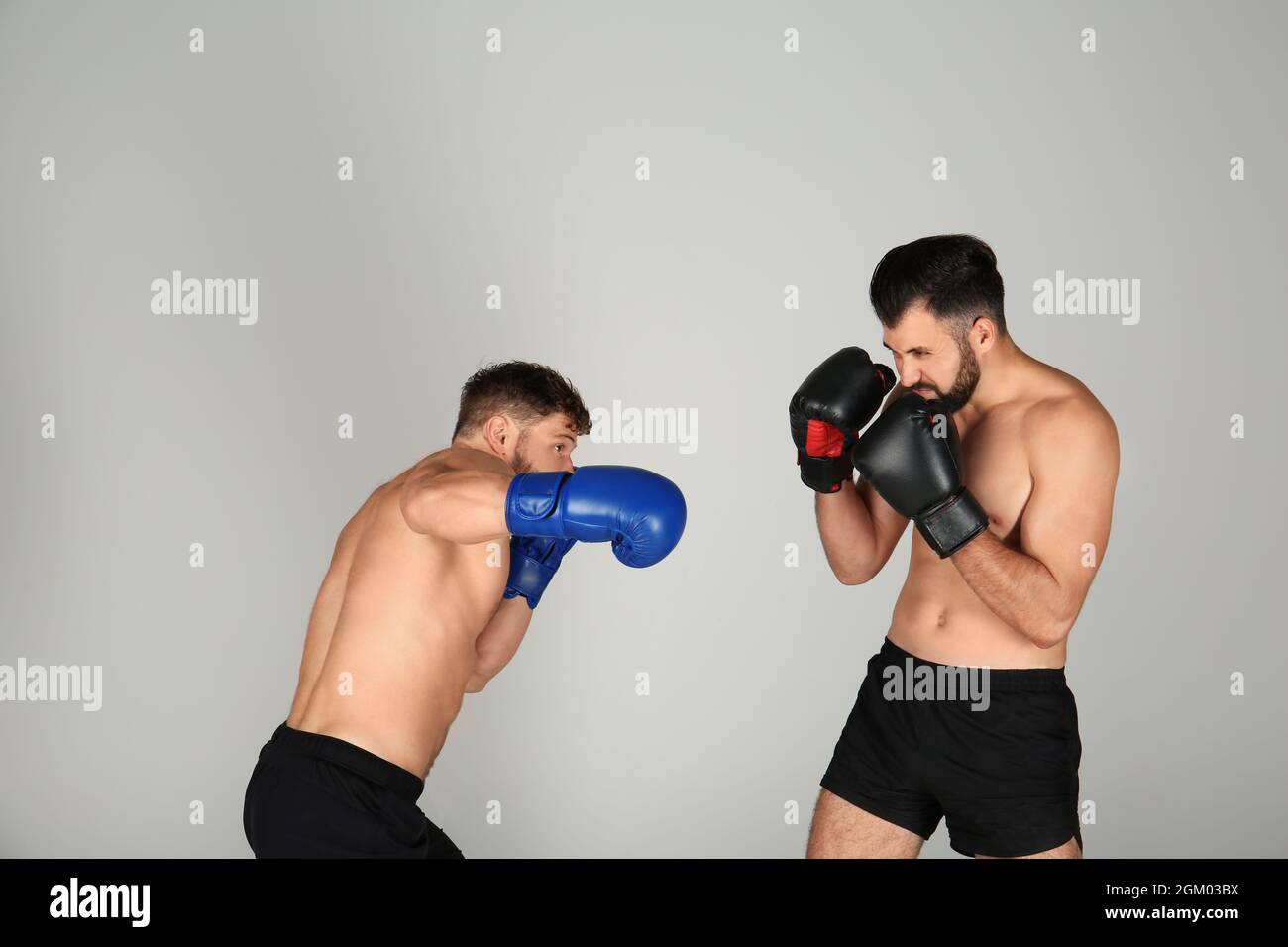 Male boxers fighting on light background Stock Photo - Alamy