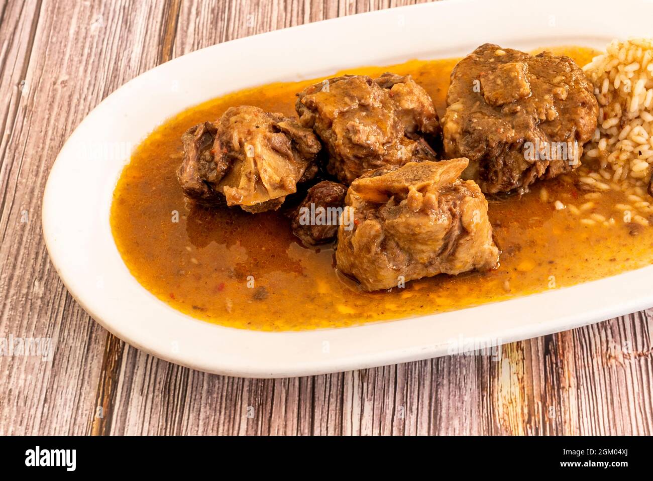 Delicious Spanish oxtail stew with white rice garnish on a white tray ...