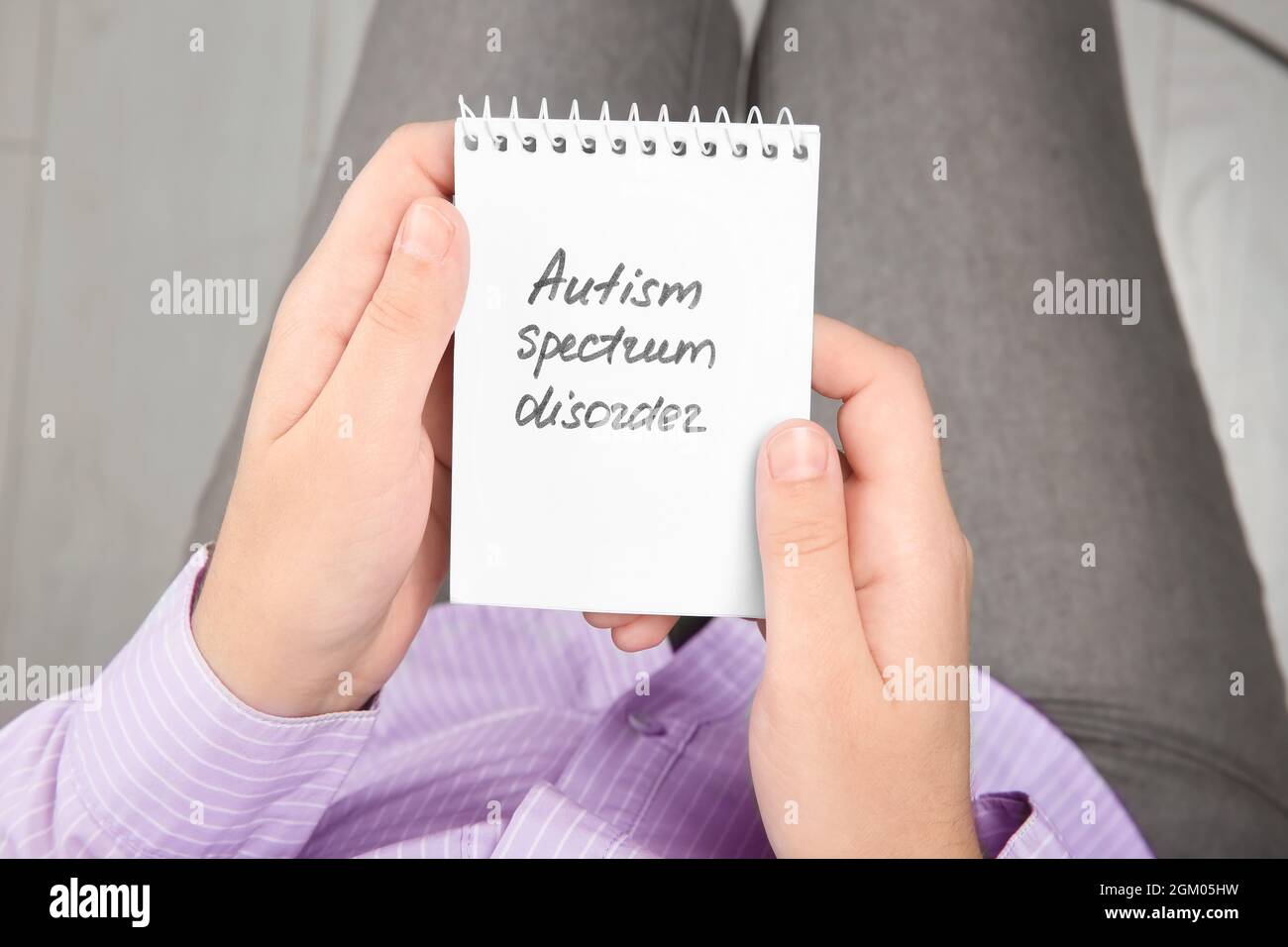 Woman holding notebook with written words "Autism spectrum disorder ...