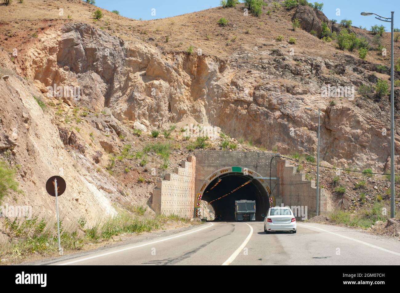 Motorway two way tunnel entrance in the mountain with car in frame ...